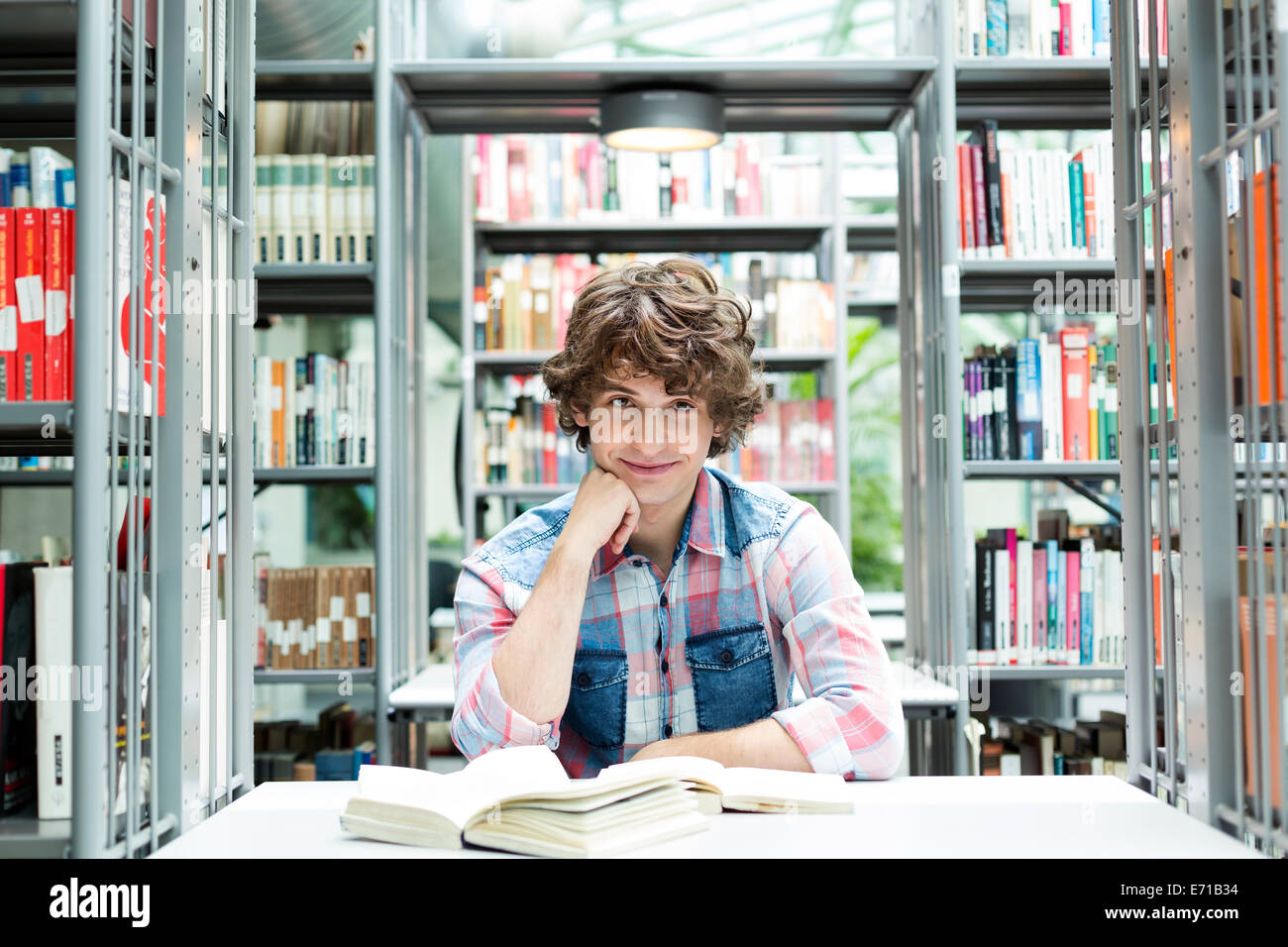 Student in a university library reading Stock Photo - Alamy