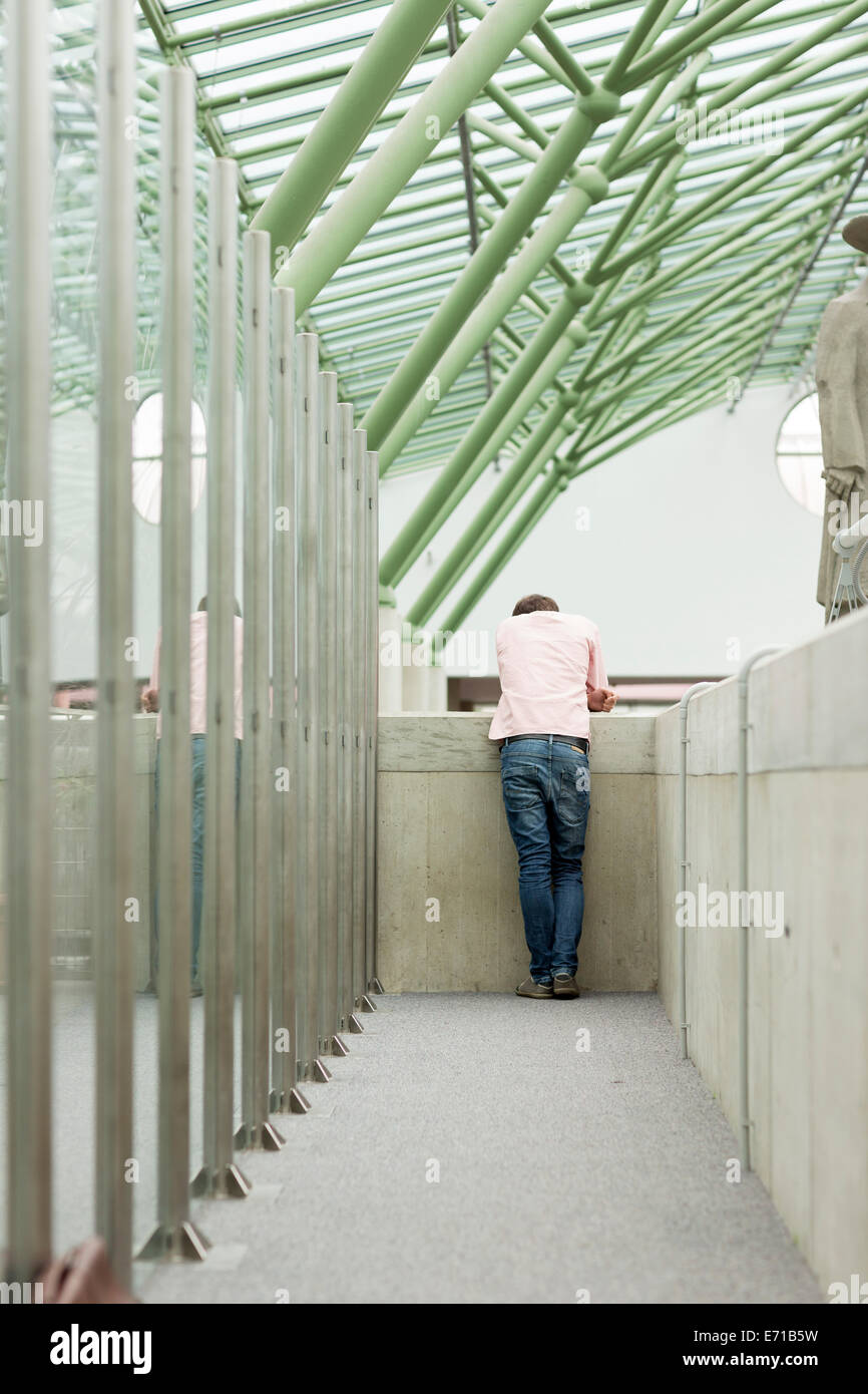 Rear view leaning against concrete railing Stock Photo - Alamy