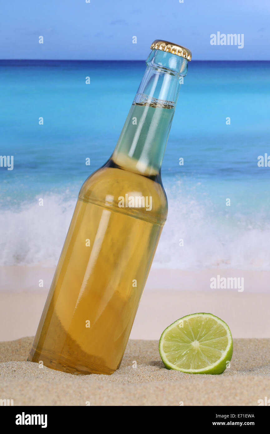 Beer in a bottle on the beach and sea in sand Stock Photo - Alamy