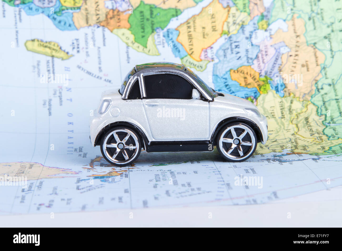 Side view of red, toy, small car on colorful map Stock Photo - Alamy