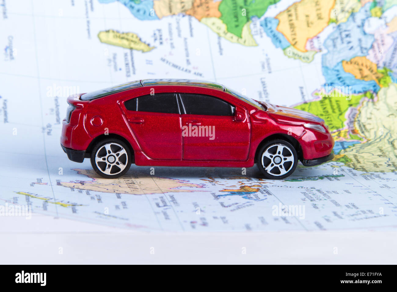 Side view of red, toy, small car on colorful map Stock Photo - Alamy