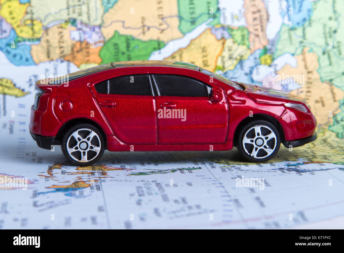 Side view of red, toy, small car on colorful map Stock Photo - Alamy