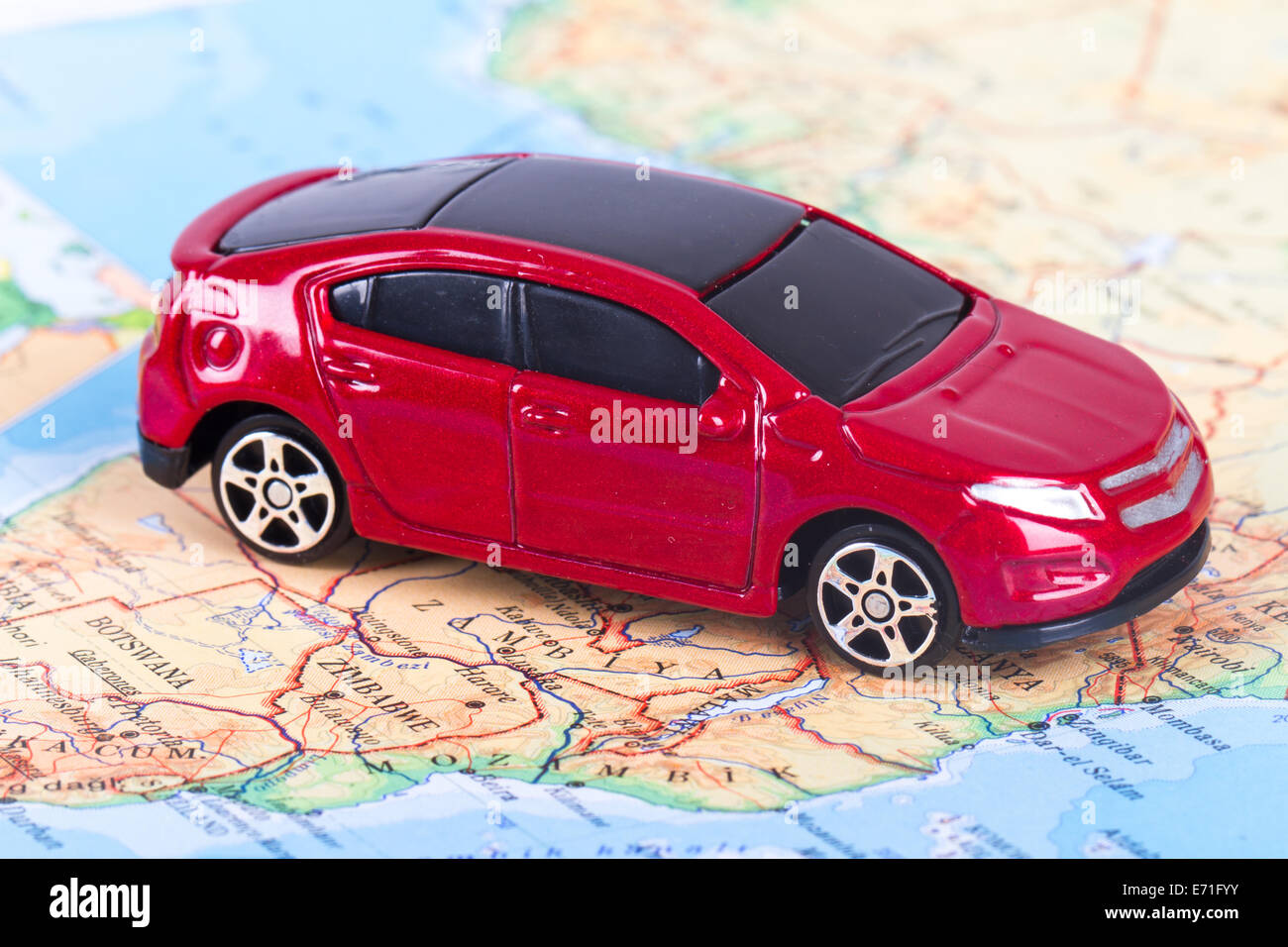 Side view of red, toy, small car on colorful map Stock Photo - Alamy