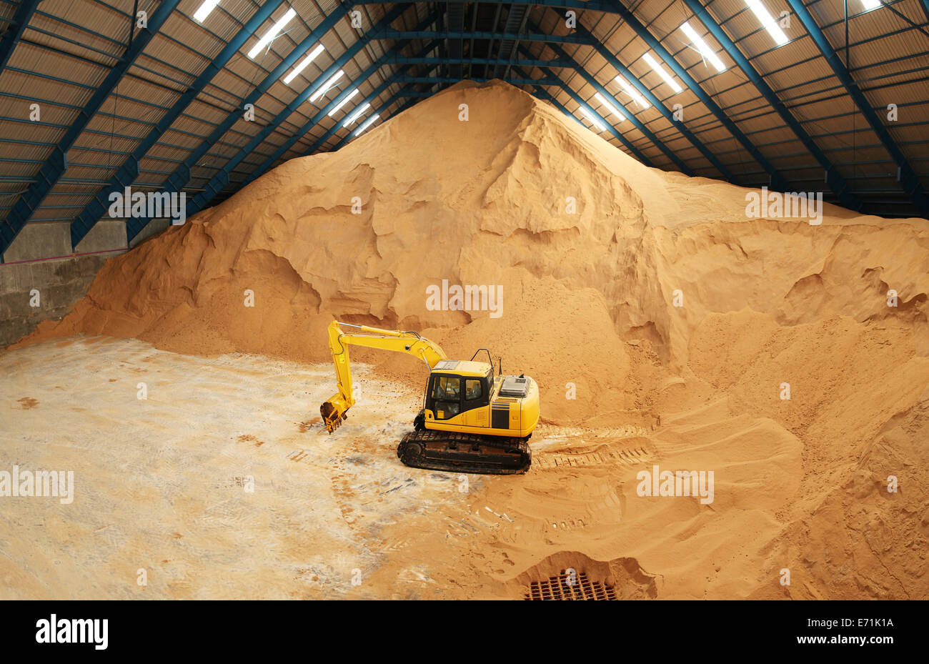 Excavator in a raw sugar factory storage building Stock Photo - Alamy