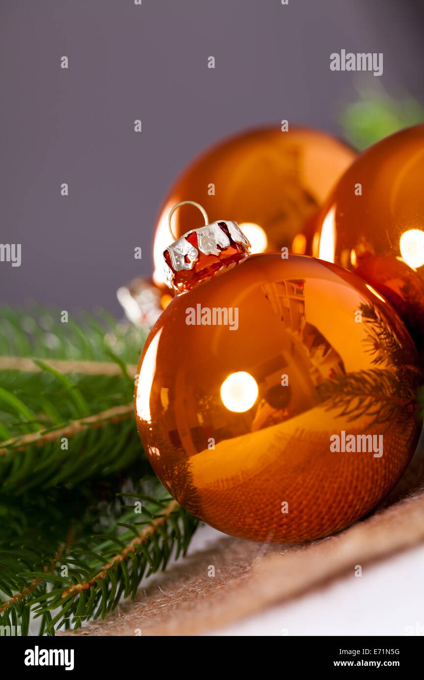 Shiny bright copper colored Christmas balls nestling in a branch of ...