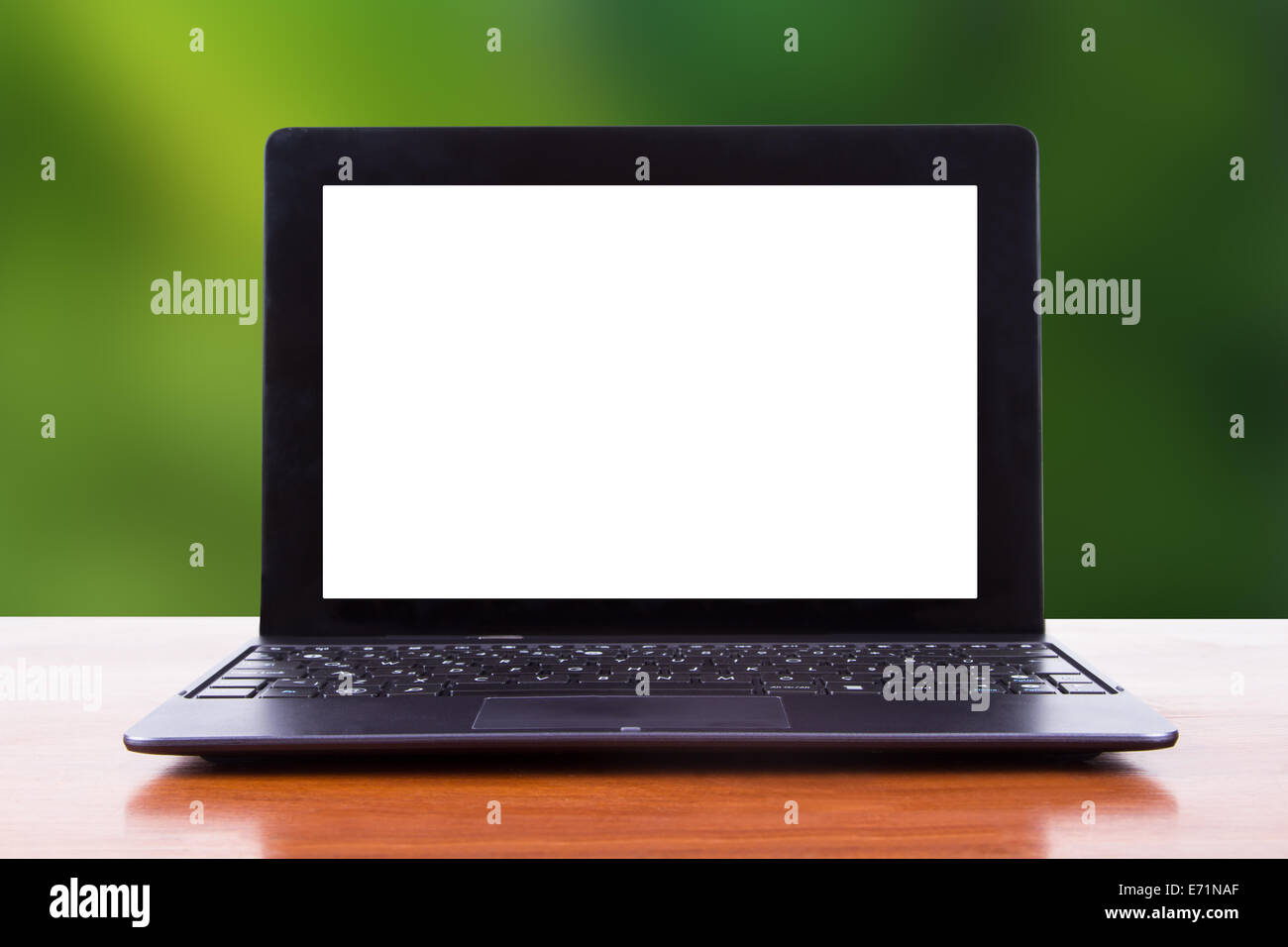 Tablet laptop with white blank screen on wooden table, front view ...