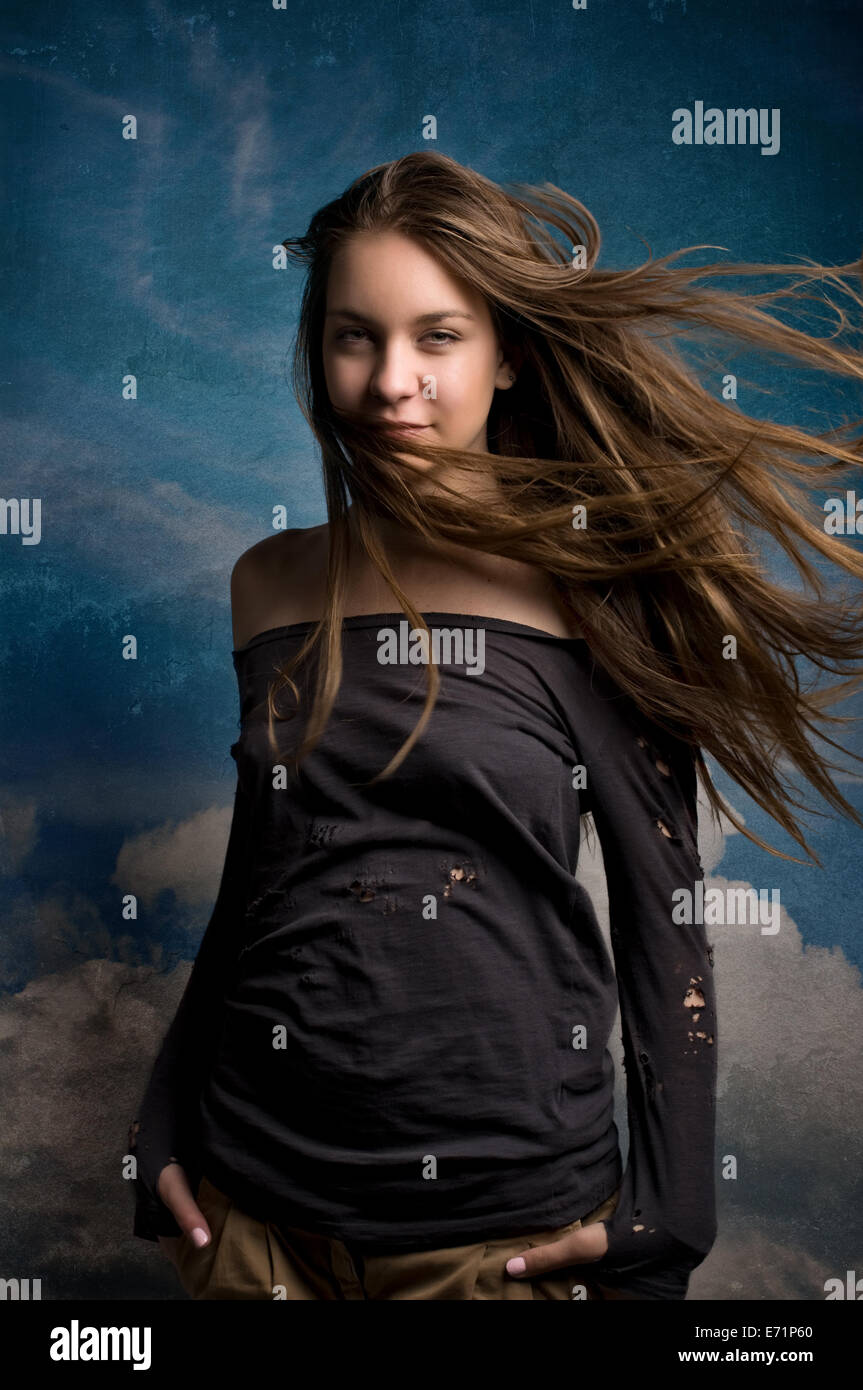 Fashion portrait of a beautiful girl with wind in her hair, posing ...