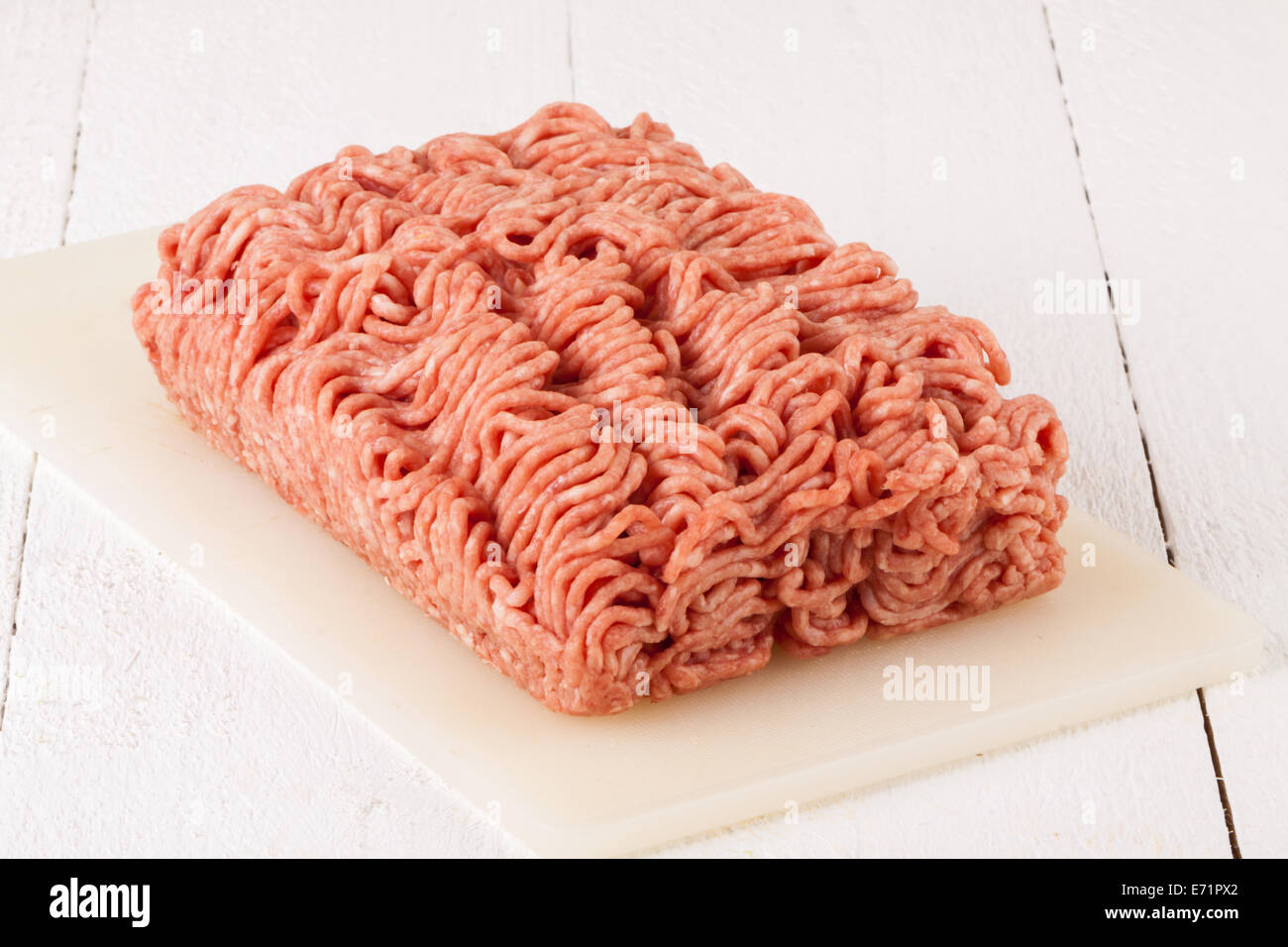Block of unwrapped raw commercial beef mince from a store showing the ...
