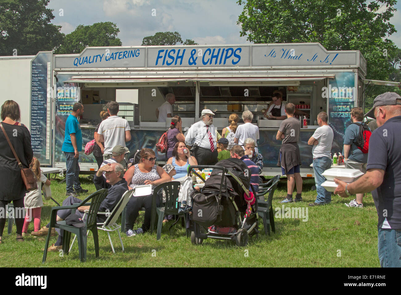 Diners, including families with children, eating at outdoor tables,and ...