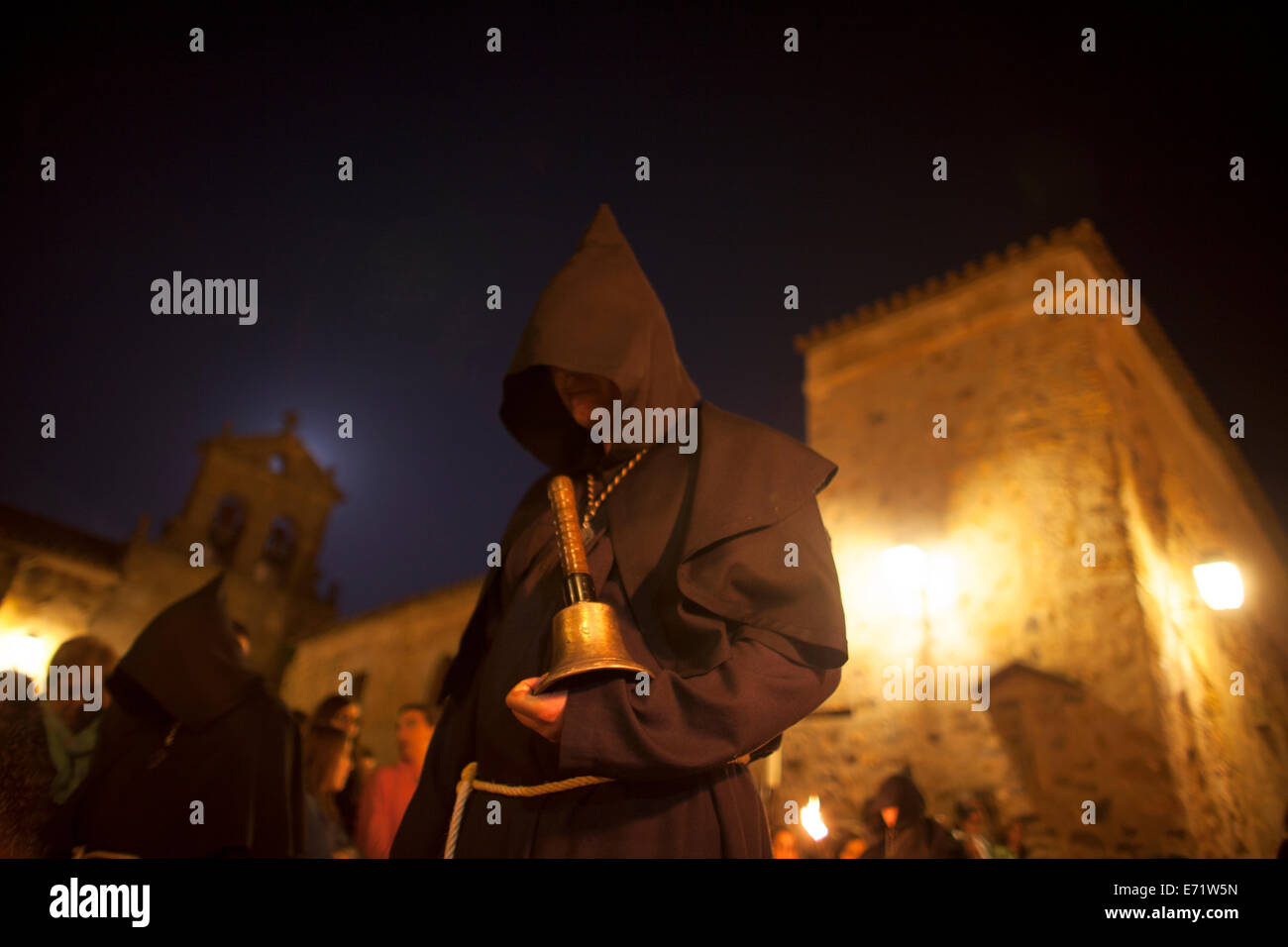 A penitent dressed as a Benedictine monk holds a bell in his hand at ...