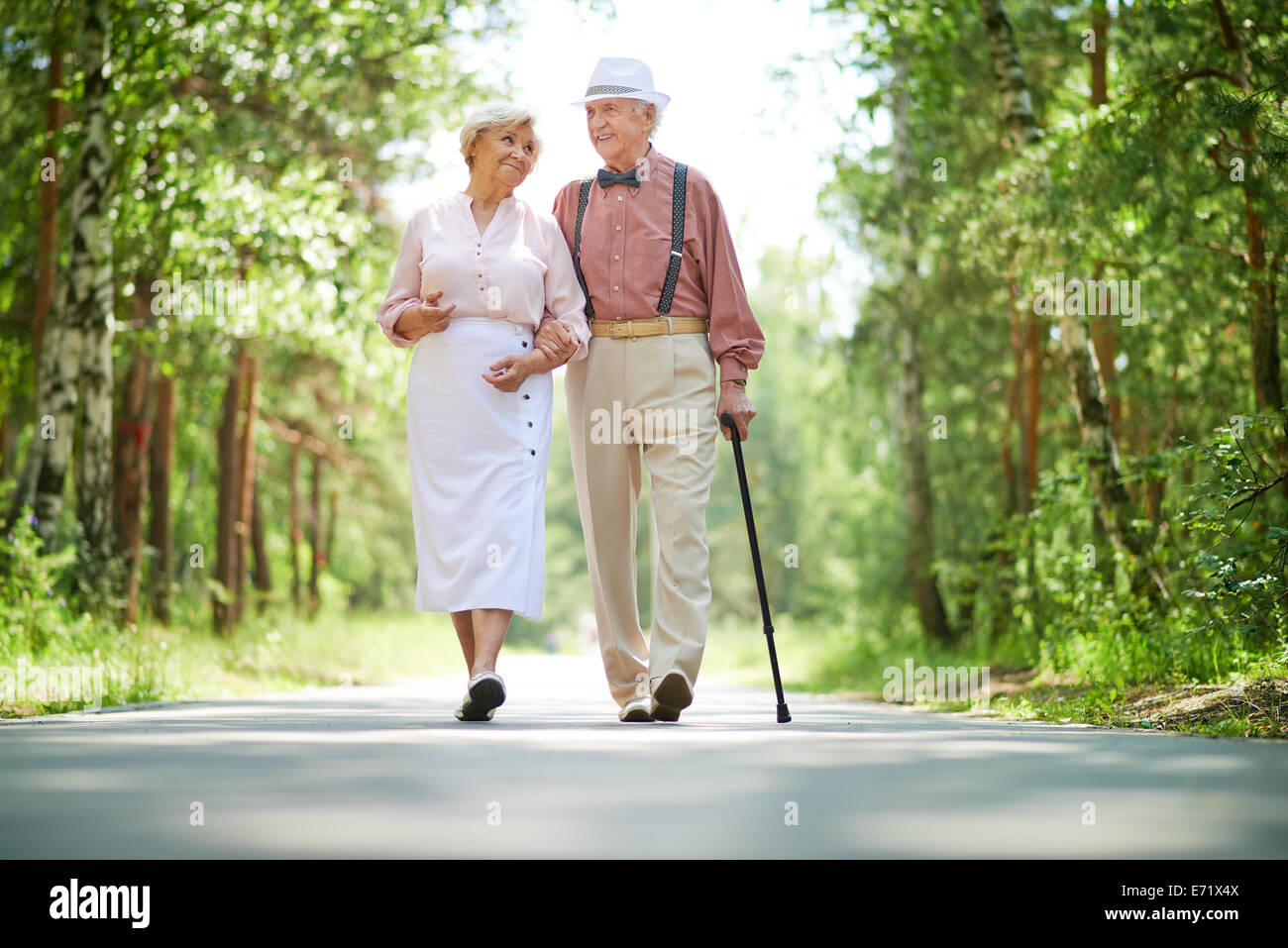 Happy seniors taking a walk in the park on sunny day Stock Photo - Alamy