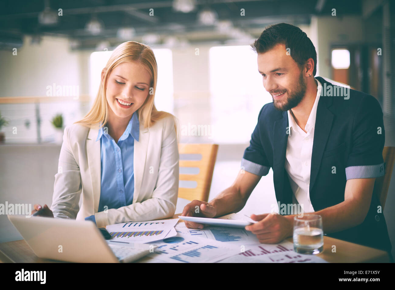 Friendly managers analyzing electronic information at meeting Stock ...