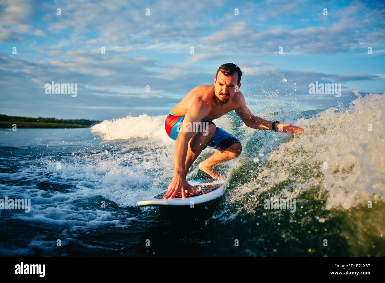 Sporty man surfboarding in the sea Stock Photo - Alamy
