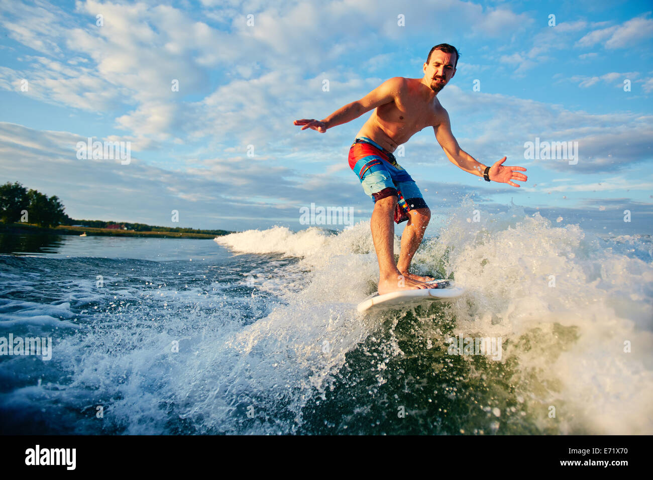 Adventurous man surfboarding in the sea Stock Photo - Alamy