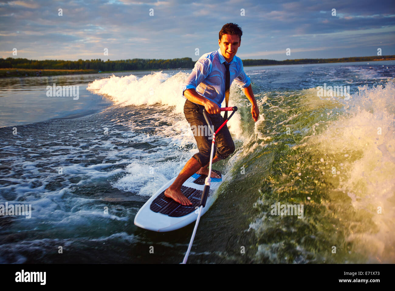 Active young man surfing on waves on vacation Stock Photo - Alamy