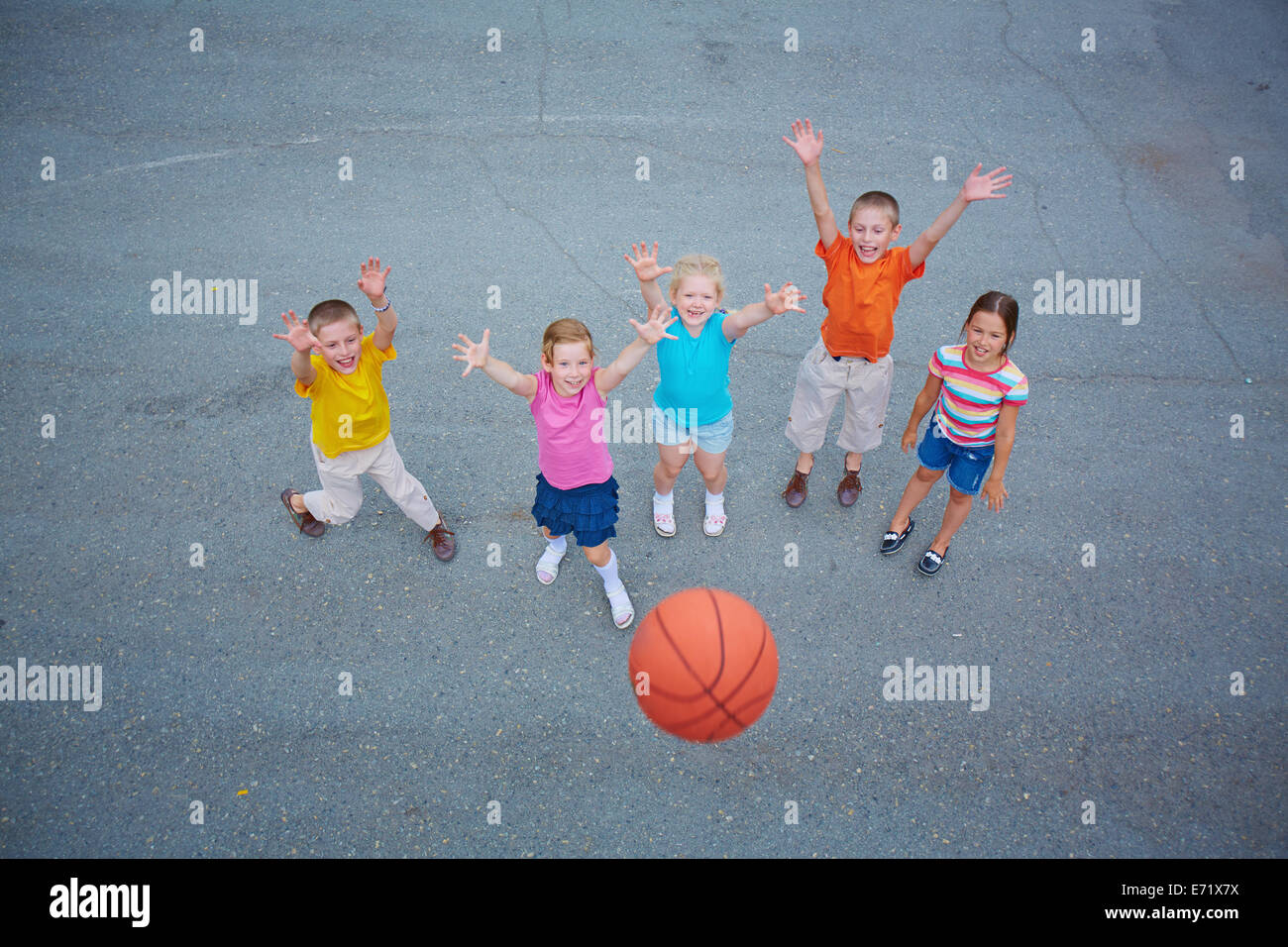 Cute friends playing basketball on sports ground Stock Photo - Alamy