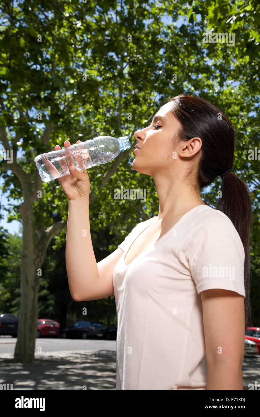 pretty brunette woman drinking water from plastic bottle Stock Photo ...