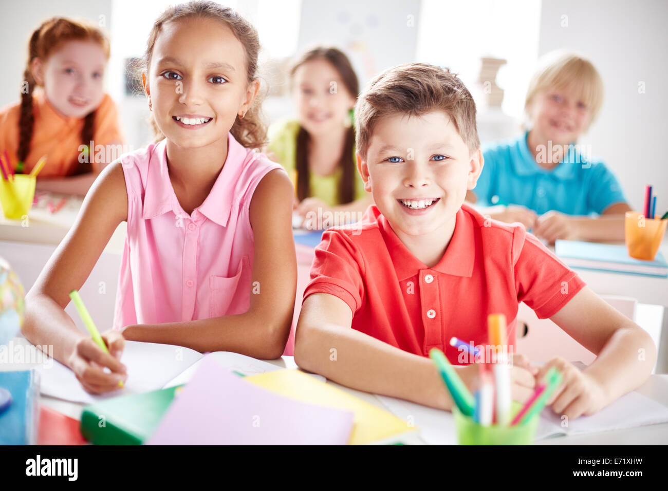 Two friendly schoolkids looking at camera at lesson Stock Photo - Alamy