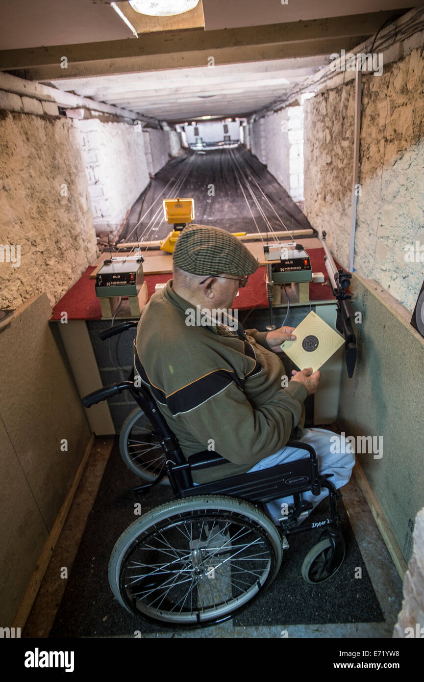 A wheelchair-using senior disabled man checking his scores on the ...