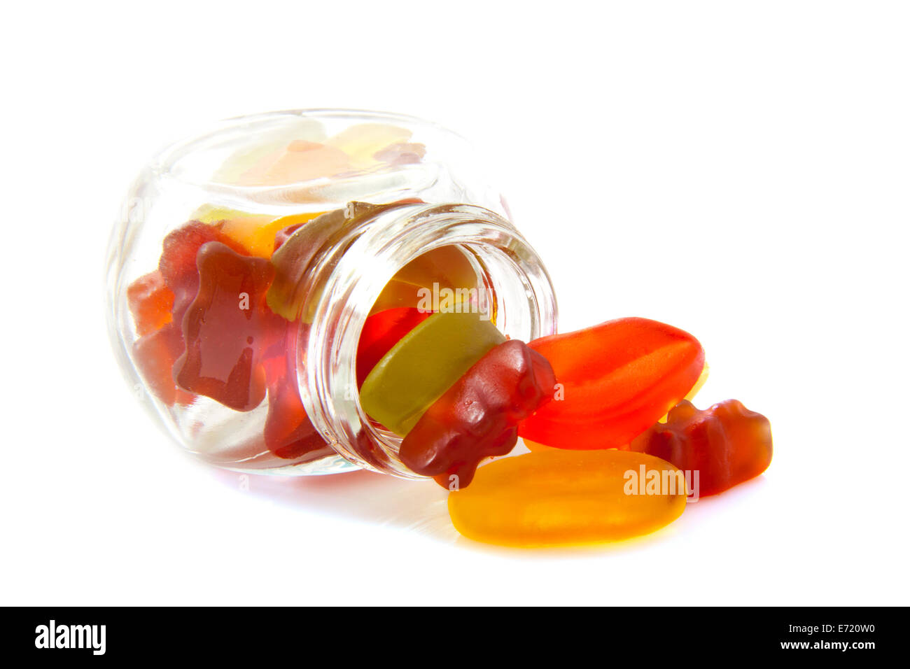 Spilled candy and a jar isolated over white Stock Photo - Alamy