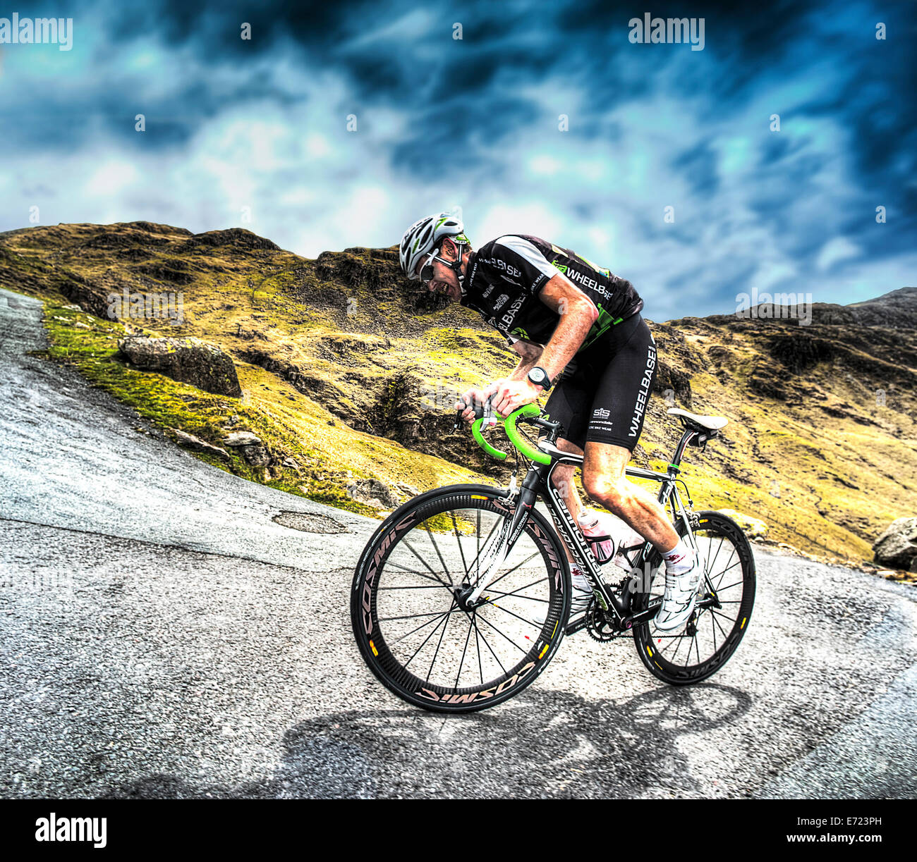 A racing cyclist climbing the steepest section of the Hardknott Pass ...