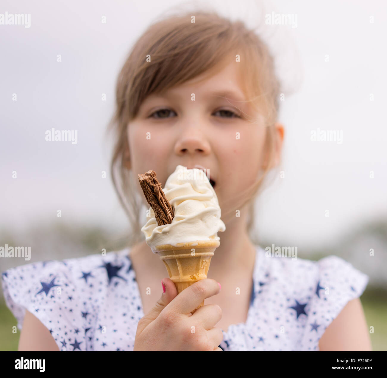 Young girl eating an ice cream looking at camera Stock Photo - Alamy