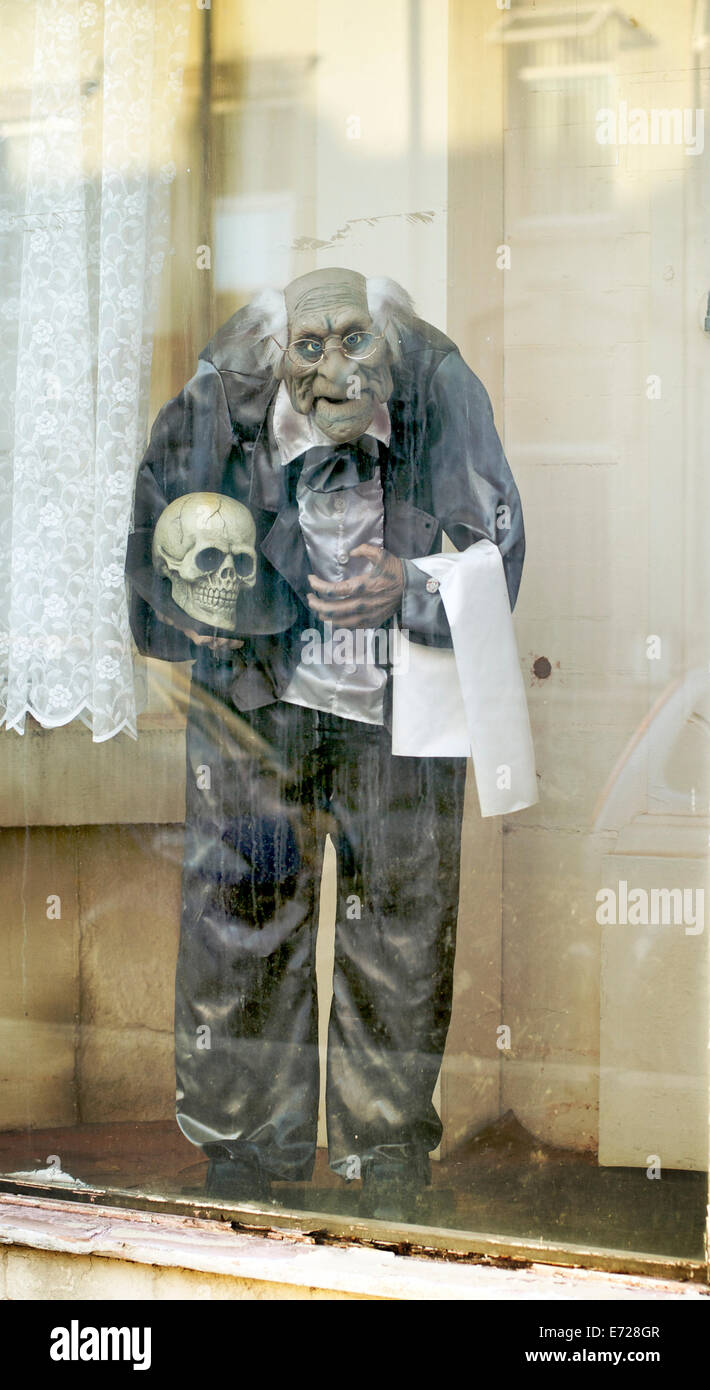 Scary butler stood in old hotel foyer holding human skull Stock Photo ...