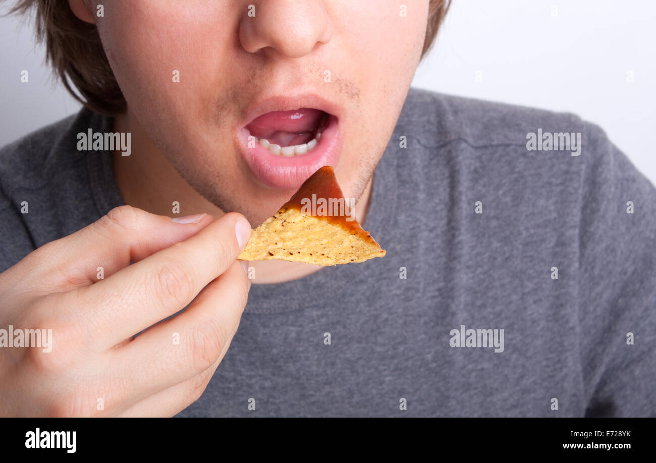young man eating nachos close up Stock Photo - Alamy