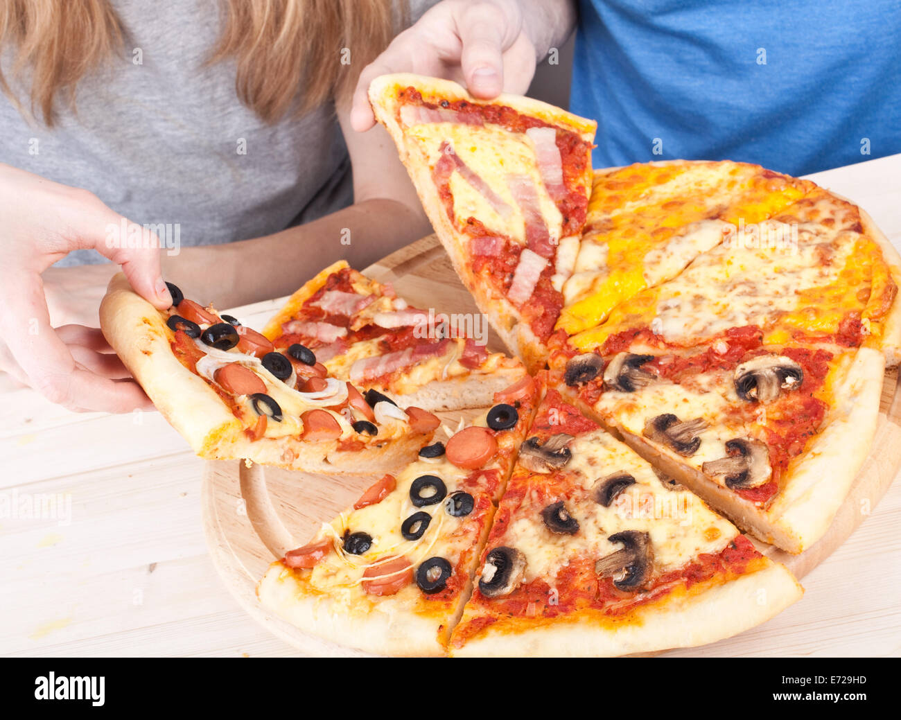 Two Young People Eating Pizza Stock Photo - Alamy