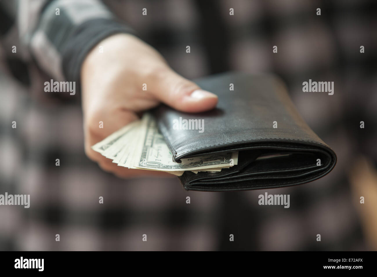 Man's hand holding a black wallet with money Stock Photo - Alamy