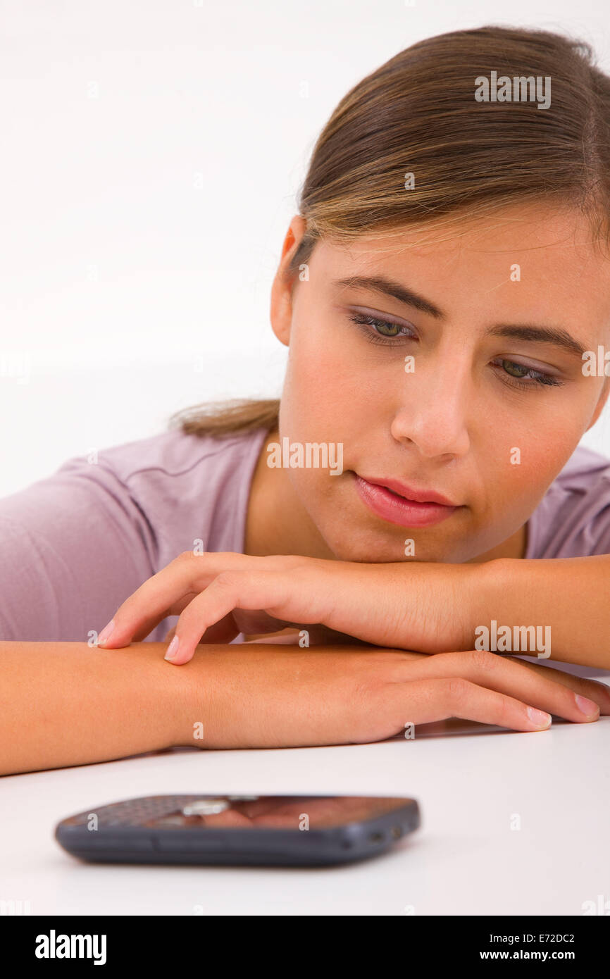 Young woman leaning forward desk looking cellphone Stock Photo - Alamy