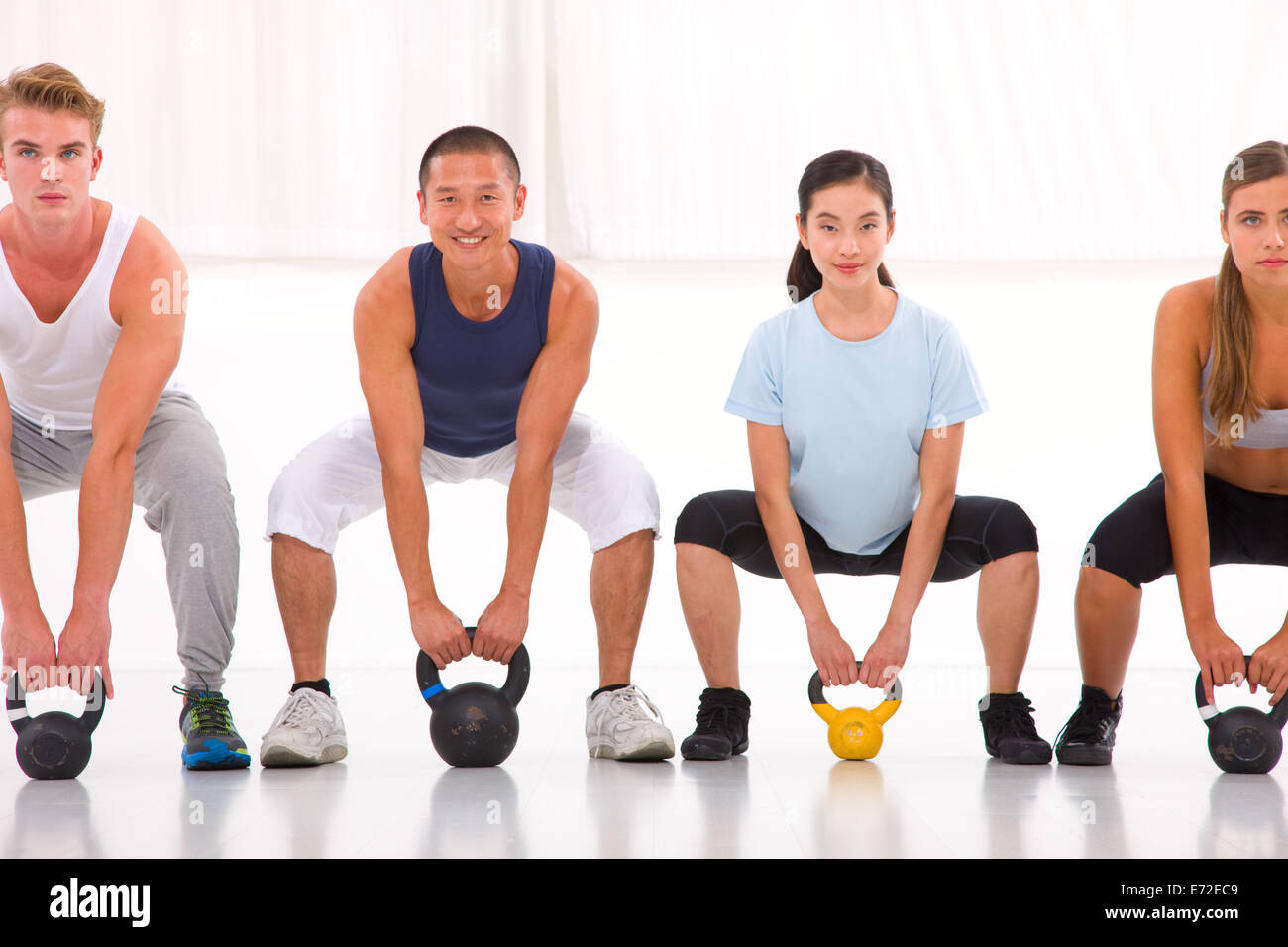 Multiethnic group of people doing kettlebell crossfit exercise Stock ...