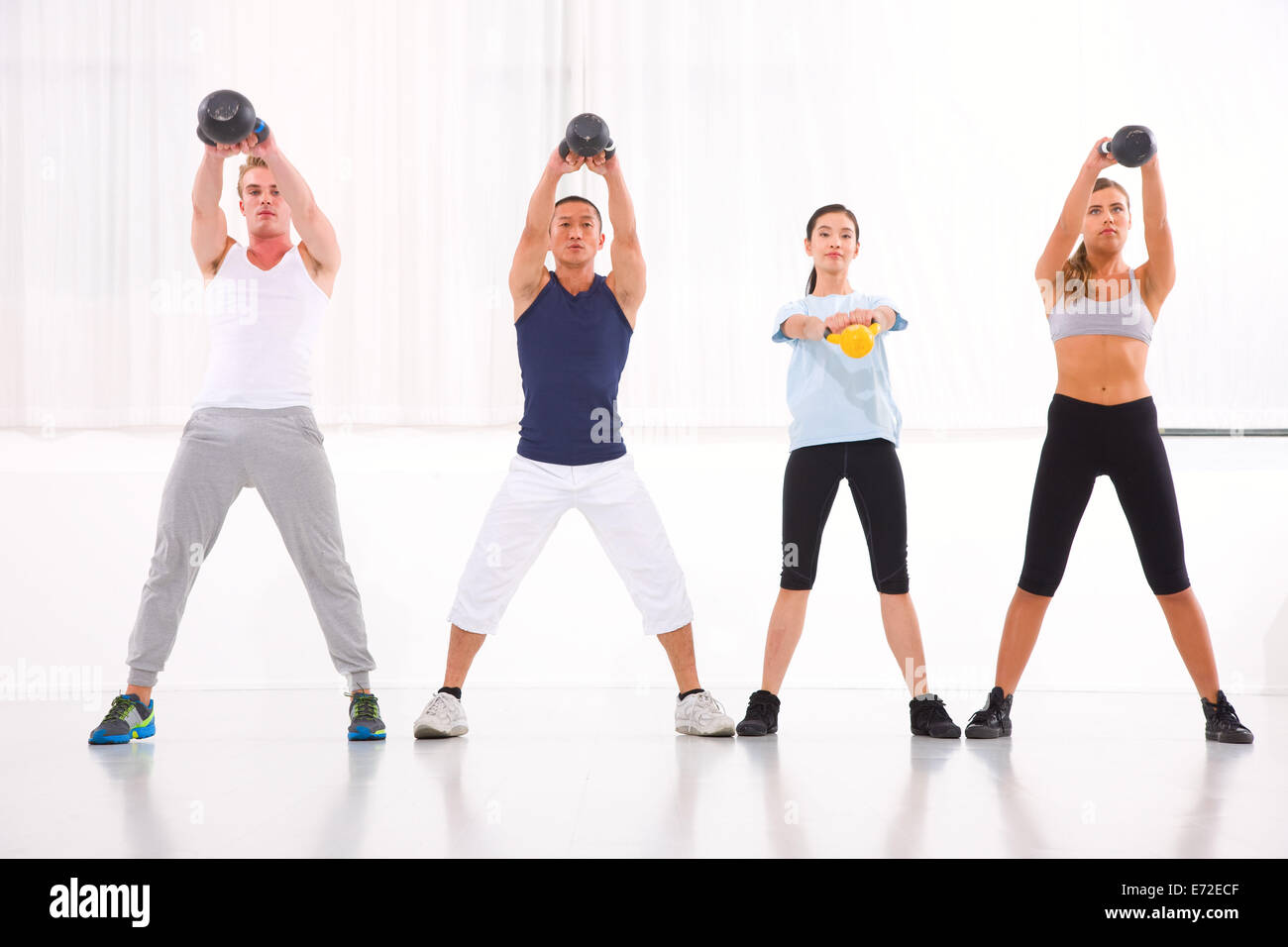 Diverse group practicing kettlebell exercise in crossfit gym Stock ...