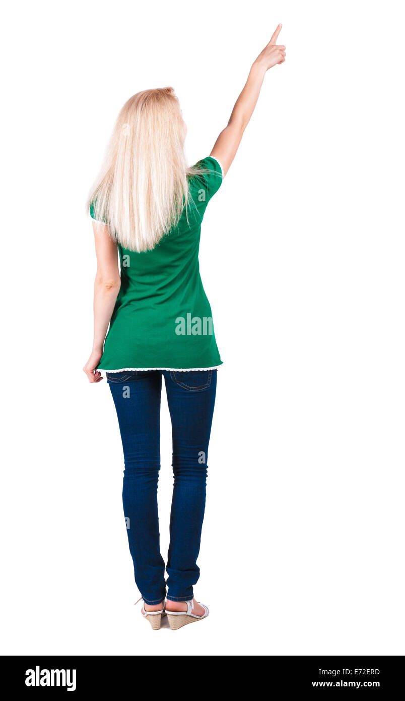 Back view of young blonde woman pointing at wall. beautiful girl in ...