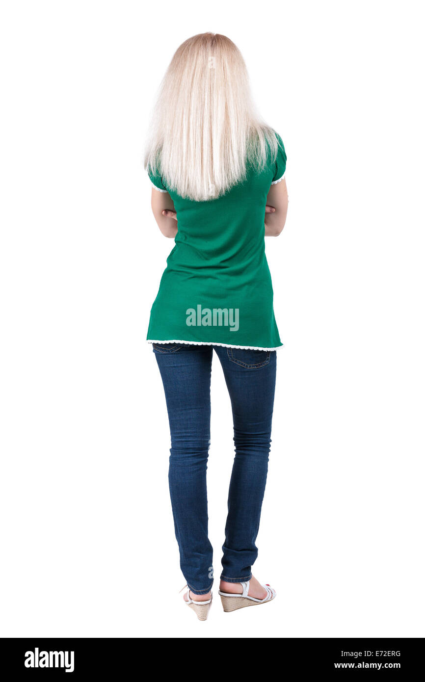 back view of standing young beautiful blonde woman. she shyly looks at ...