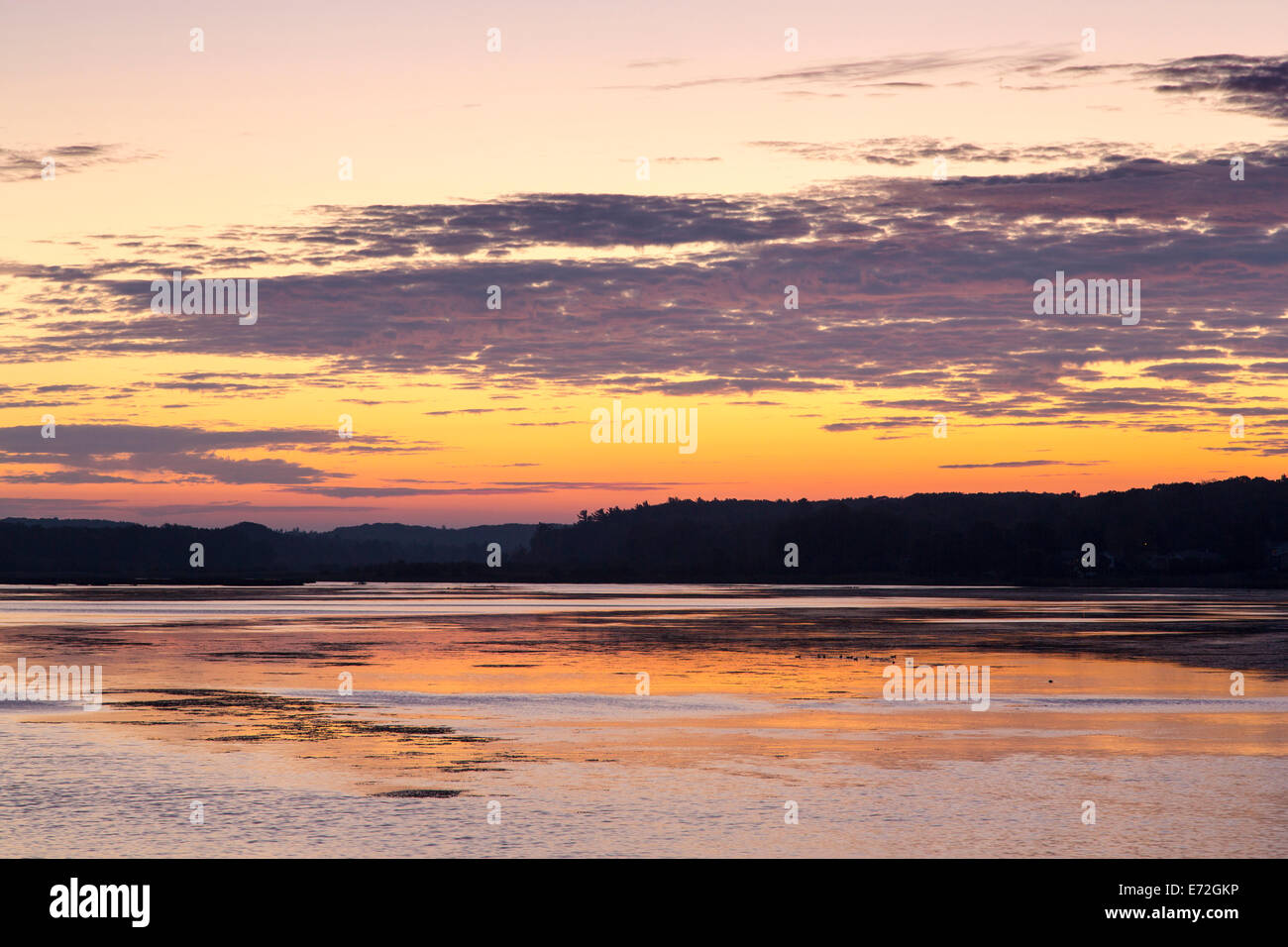 Sunrise clouds reflect into Lincoln Lake in Ludington, Michigan, USA ...