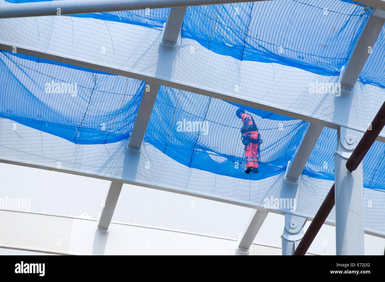 Worker on safety netting on the new roof which is being constructed at ...