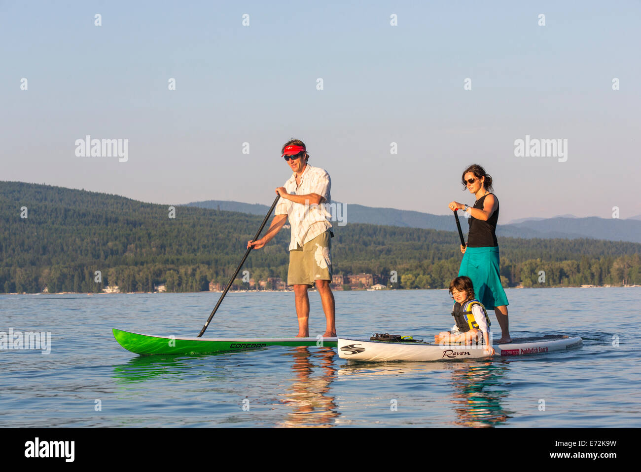 Family with standup paddle boards at Whitefish Lake State Park, Montana ...