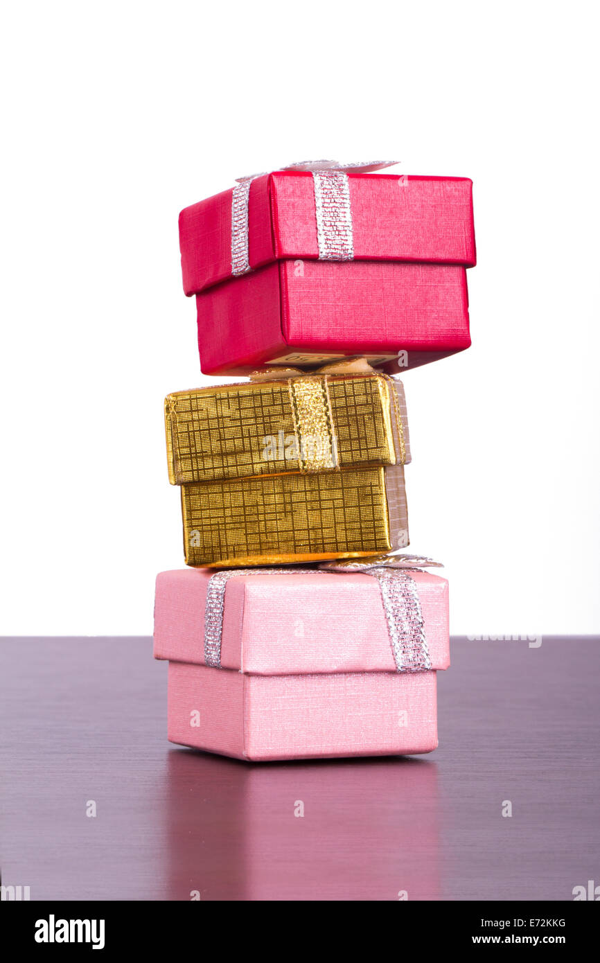 Three colorful gift boxes in row on wooden table, isolated on white ...
