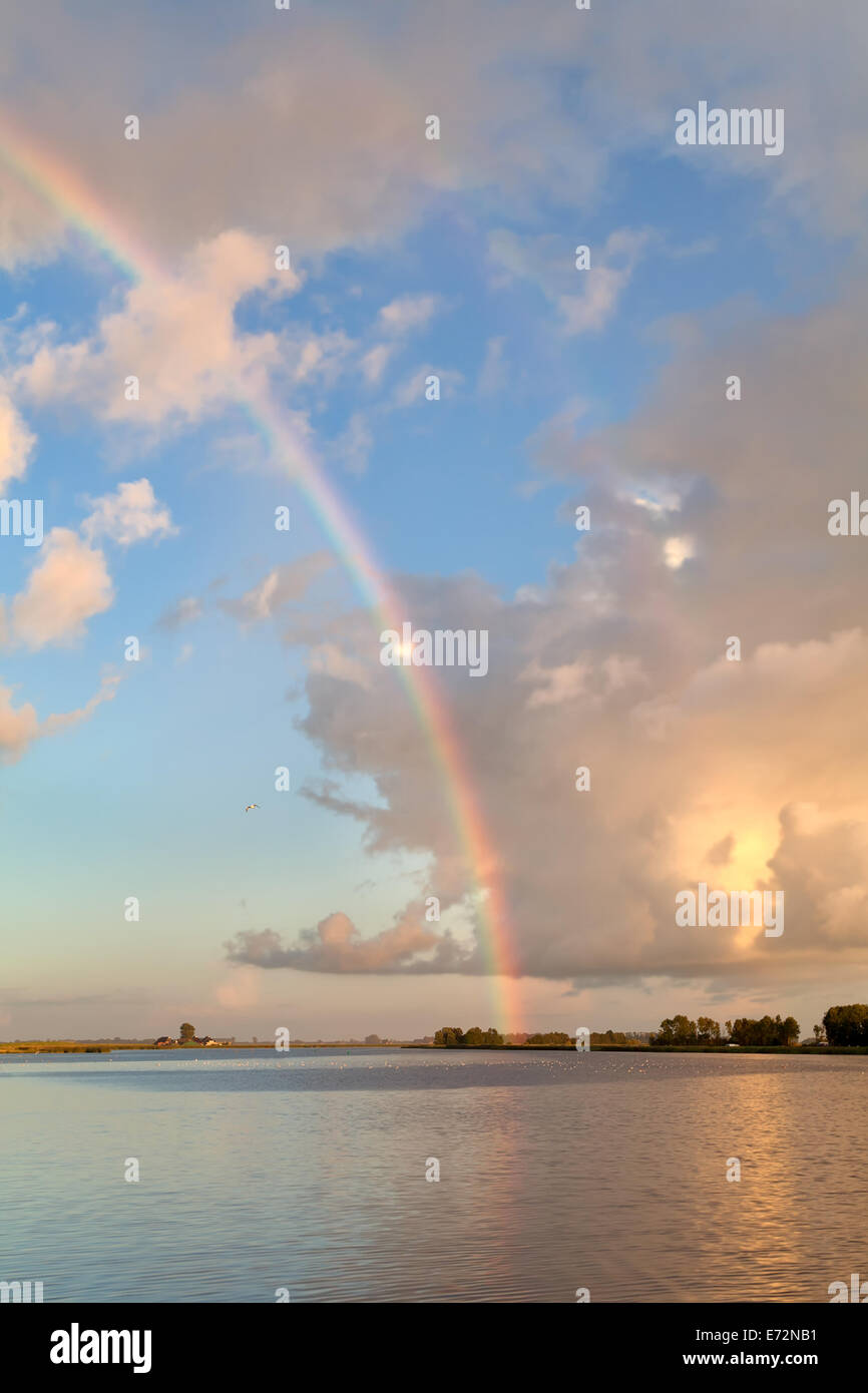 beautiful rainbow over lake at sunset Stock Photo - Alamy