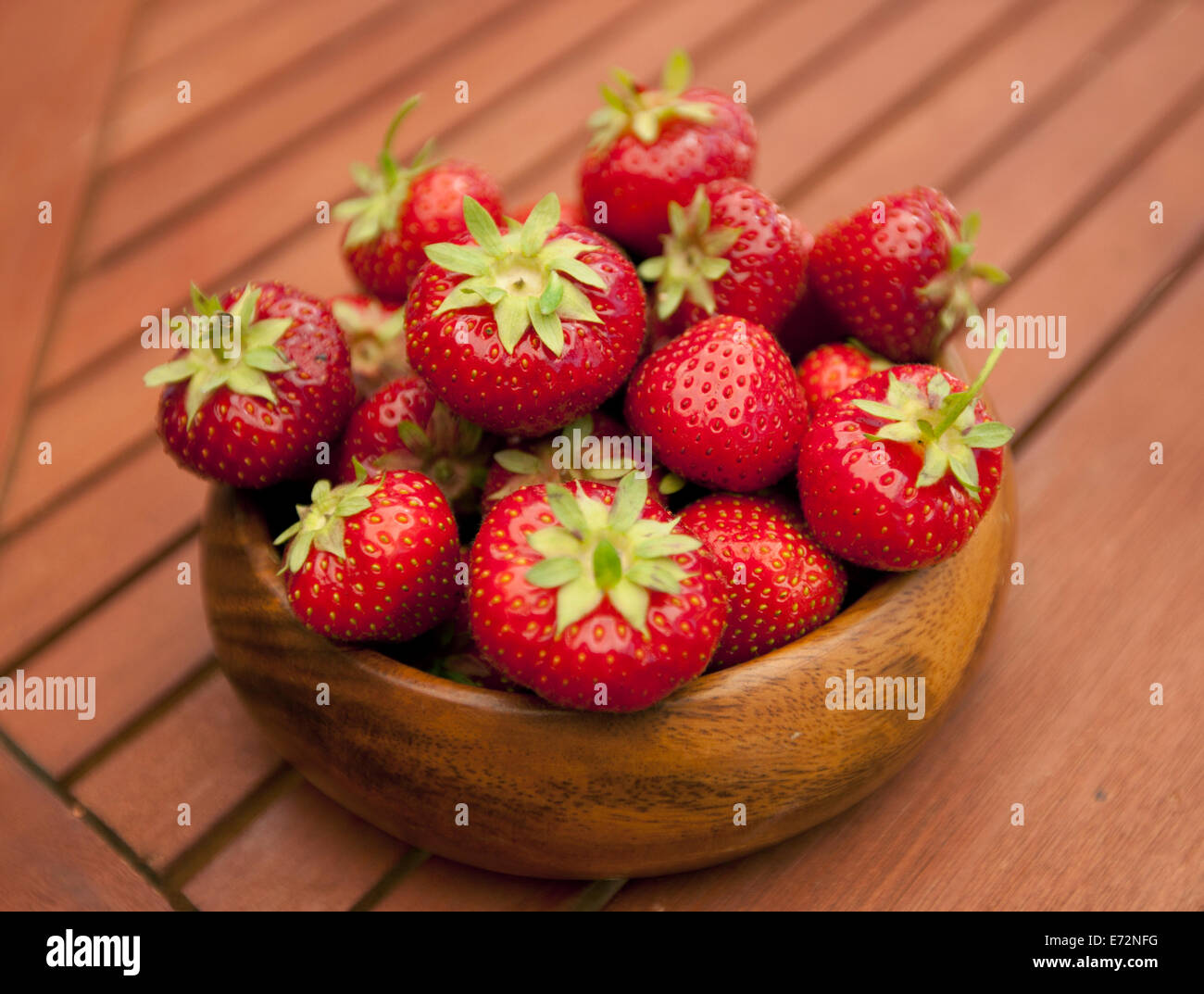 Fresh strawberries in wood bowl on table Stock Photo - Alamy