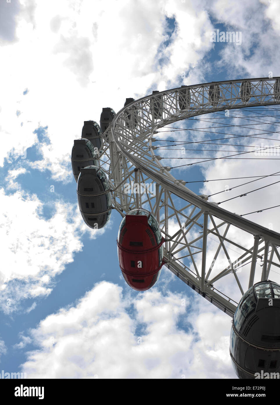 The London Eye wheel silhouetted against a blue sky with fluffy white ...