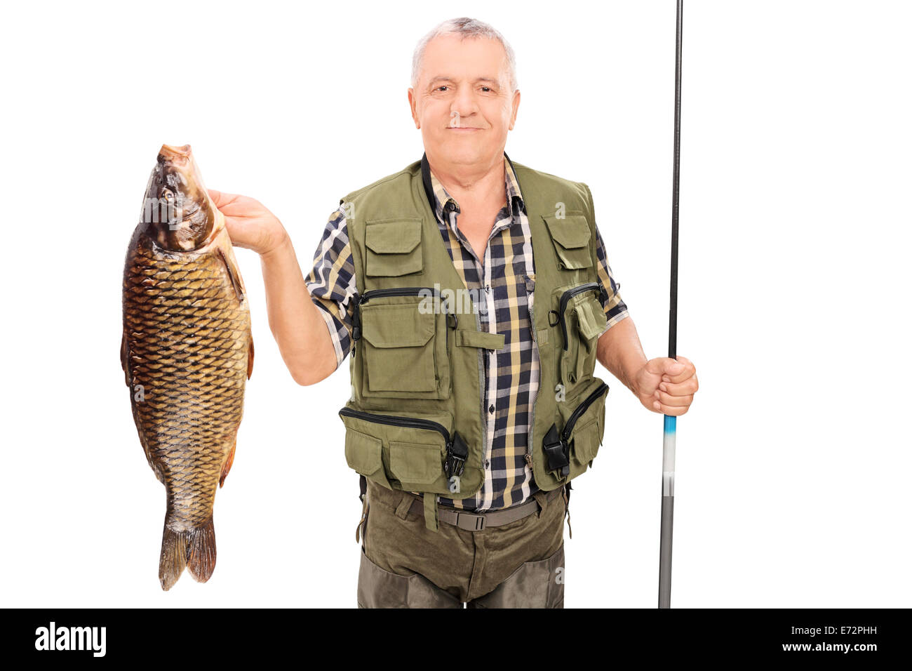 Mature fisherman holding big fish and fishing rod isolated on white ...