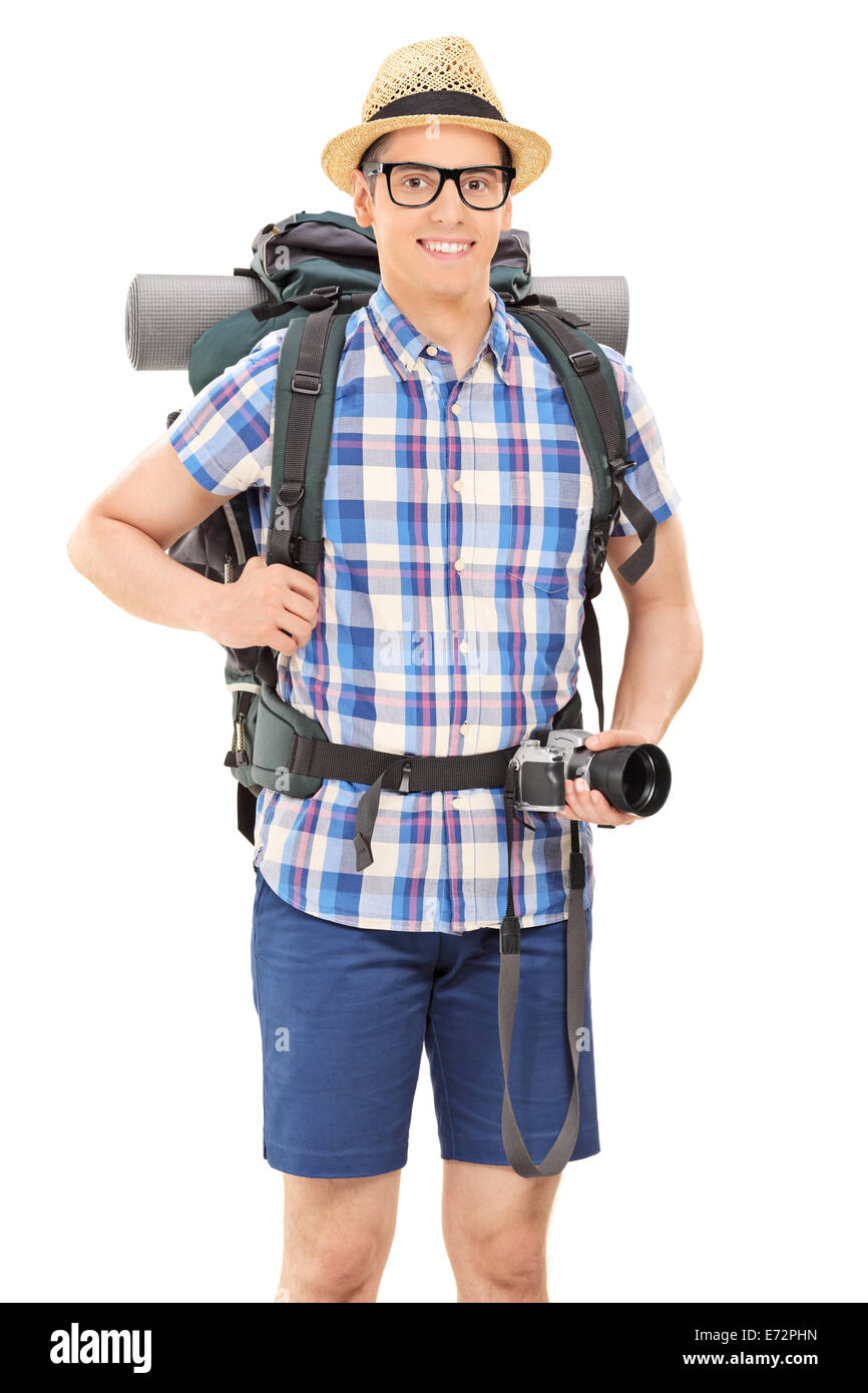 Young male hiker holding a camera and posing isolated on white ...