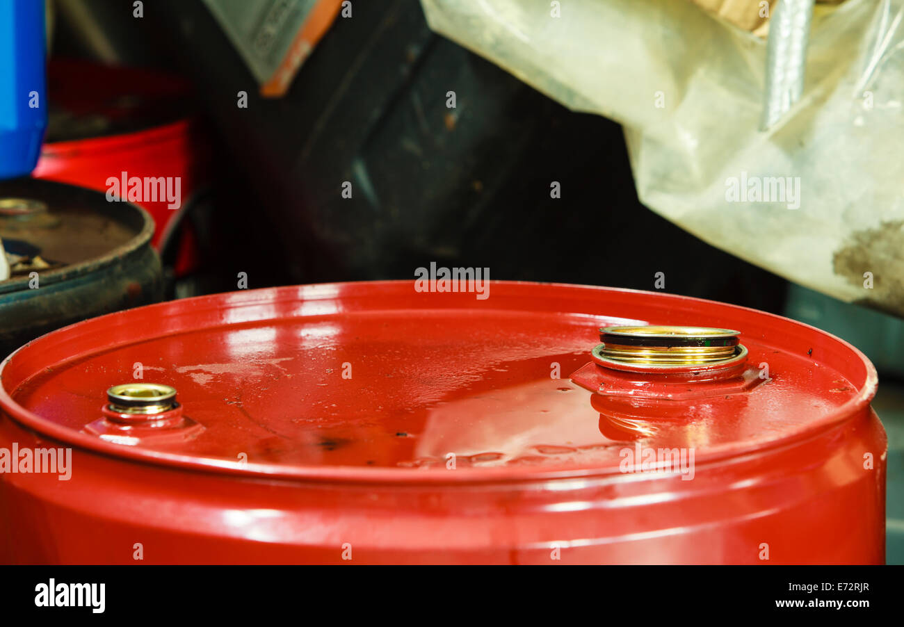 Car servicing oil change. Red oil barrel canister in mechanic garage ...