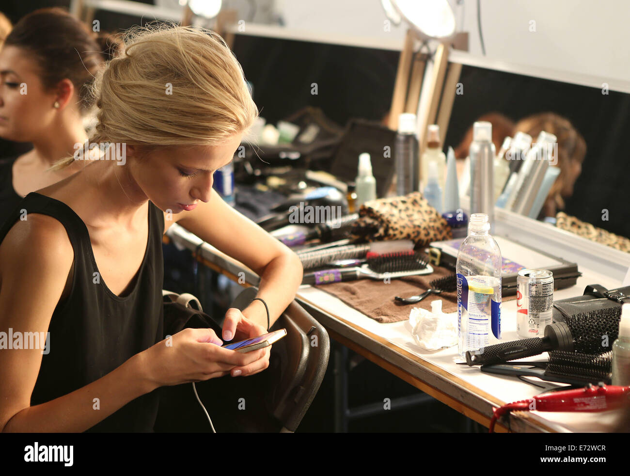 New York, USA. 4th Sep, 2014. A model uses her mobile phone backstage ...
