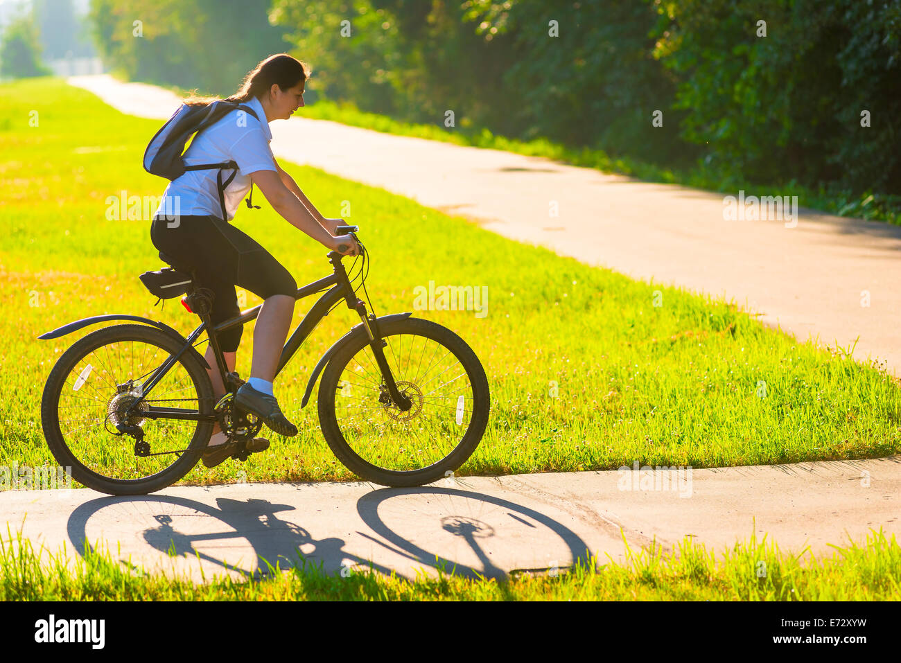 girl on bike rides on the bike path in the park Stock Photo - Alamy