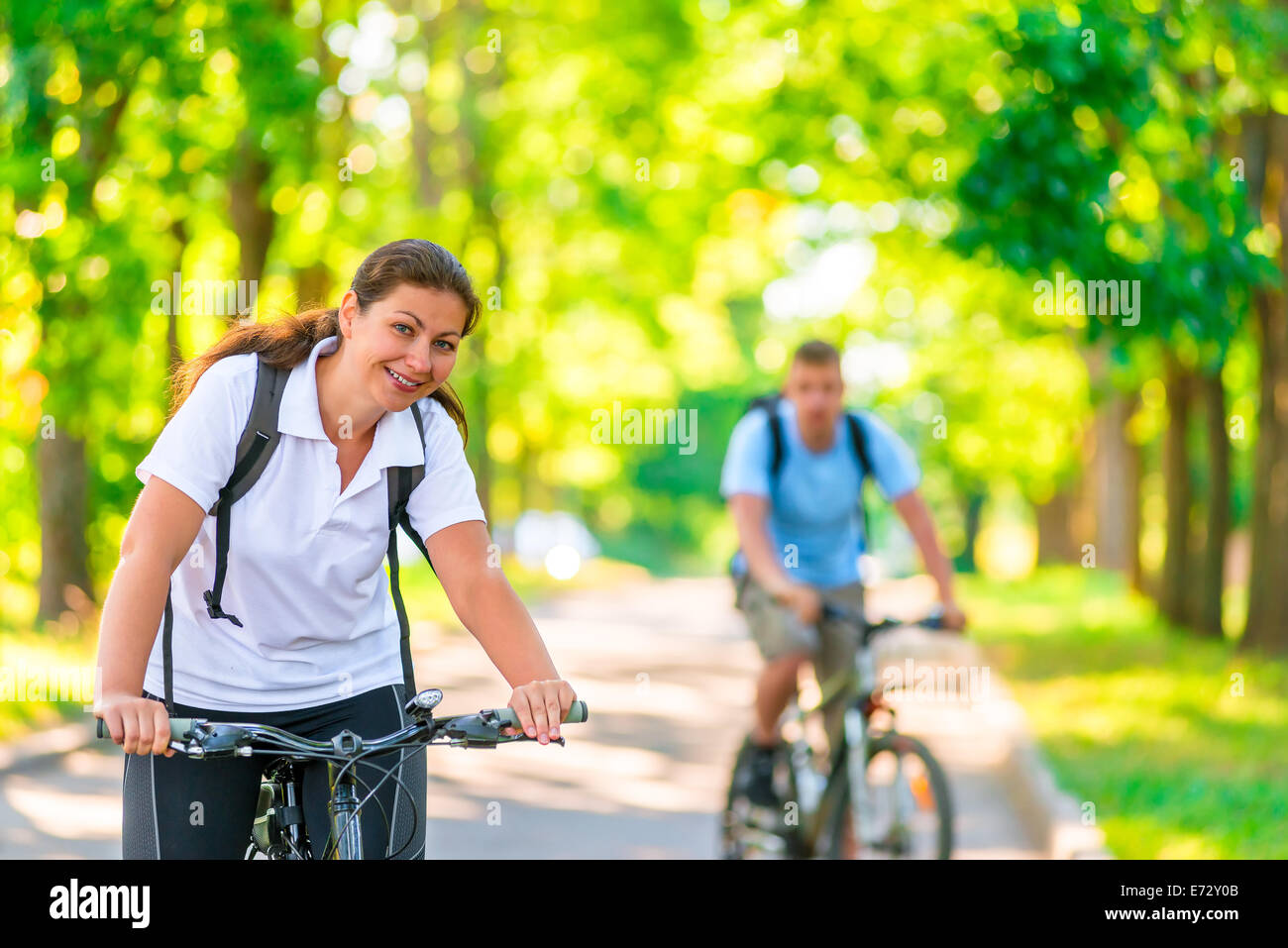 a couple of cyclists riding in the park Stock Photo - Alamy
