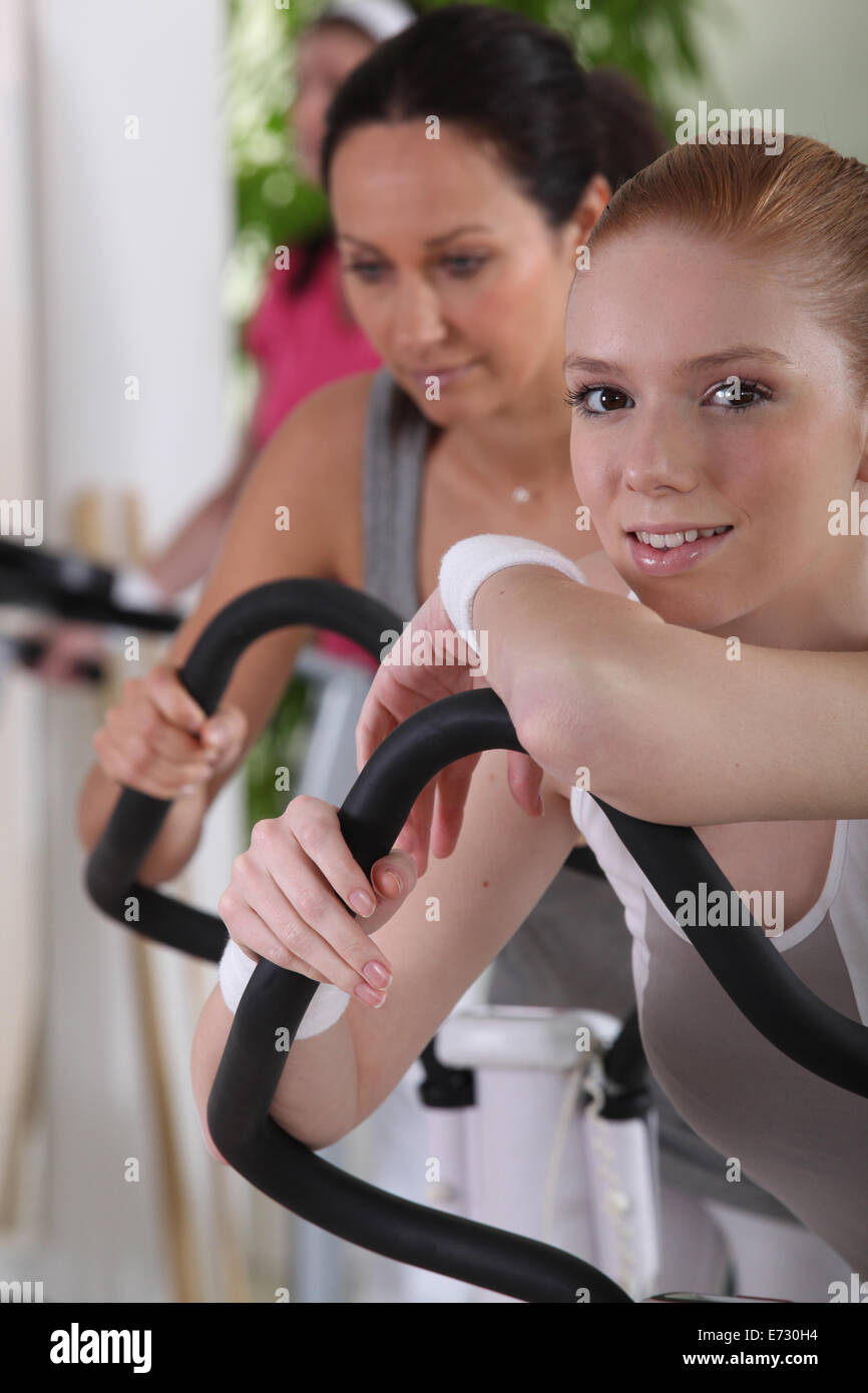 Woman using gym equipment Stock Photo - Alamy