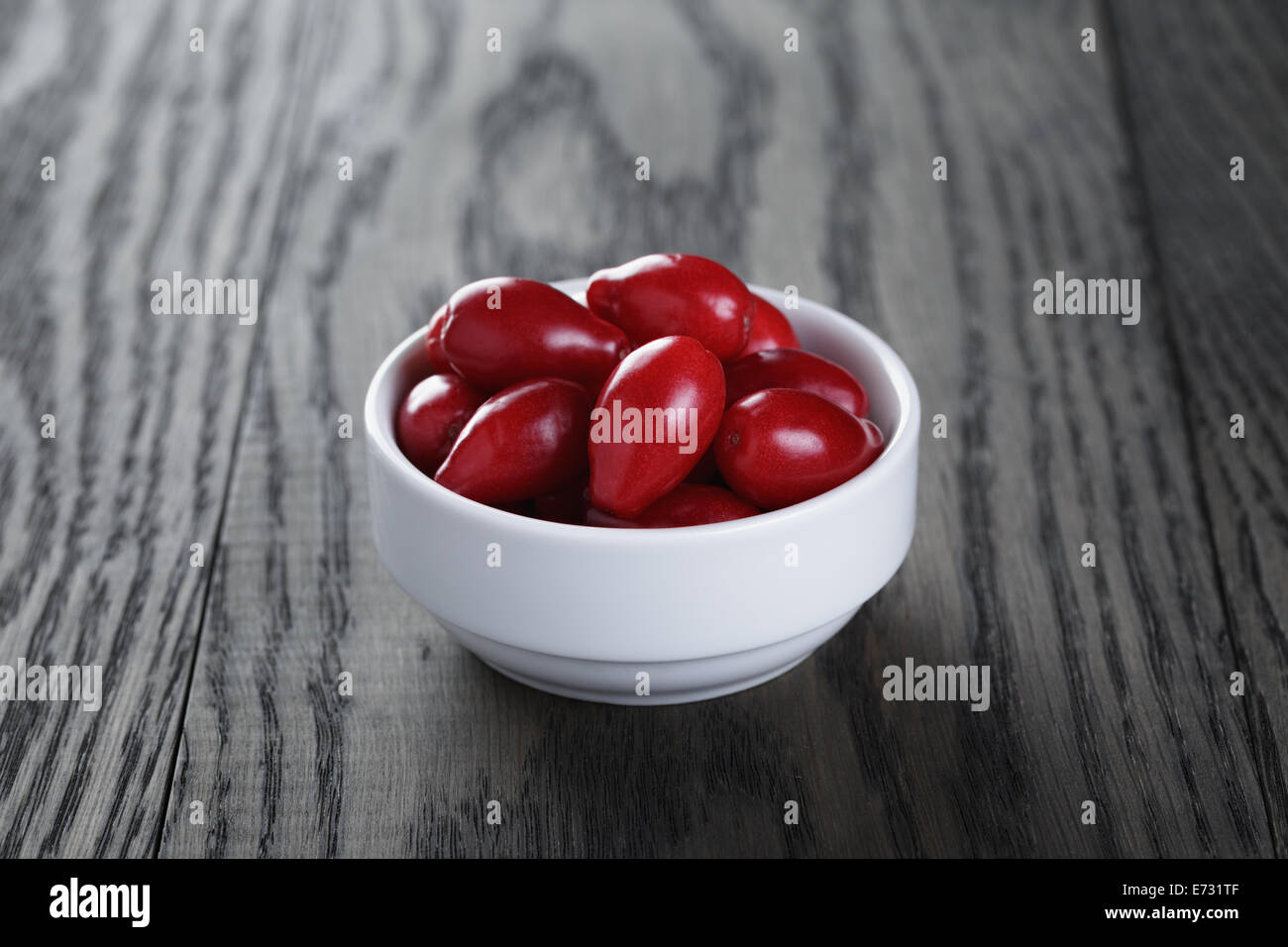 ripe cornel berries in bowl, on old wood table Stock Photo - Alamy